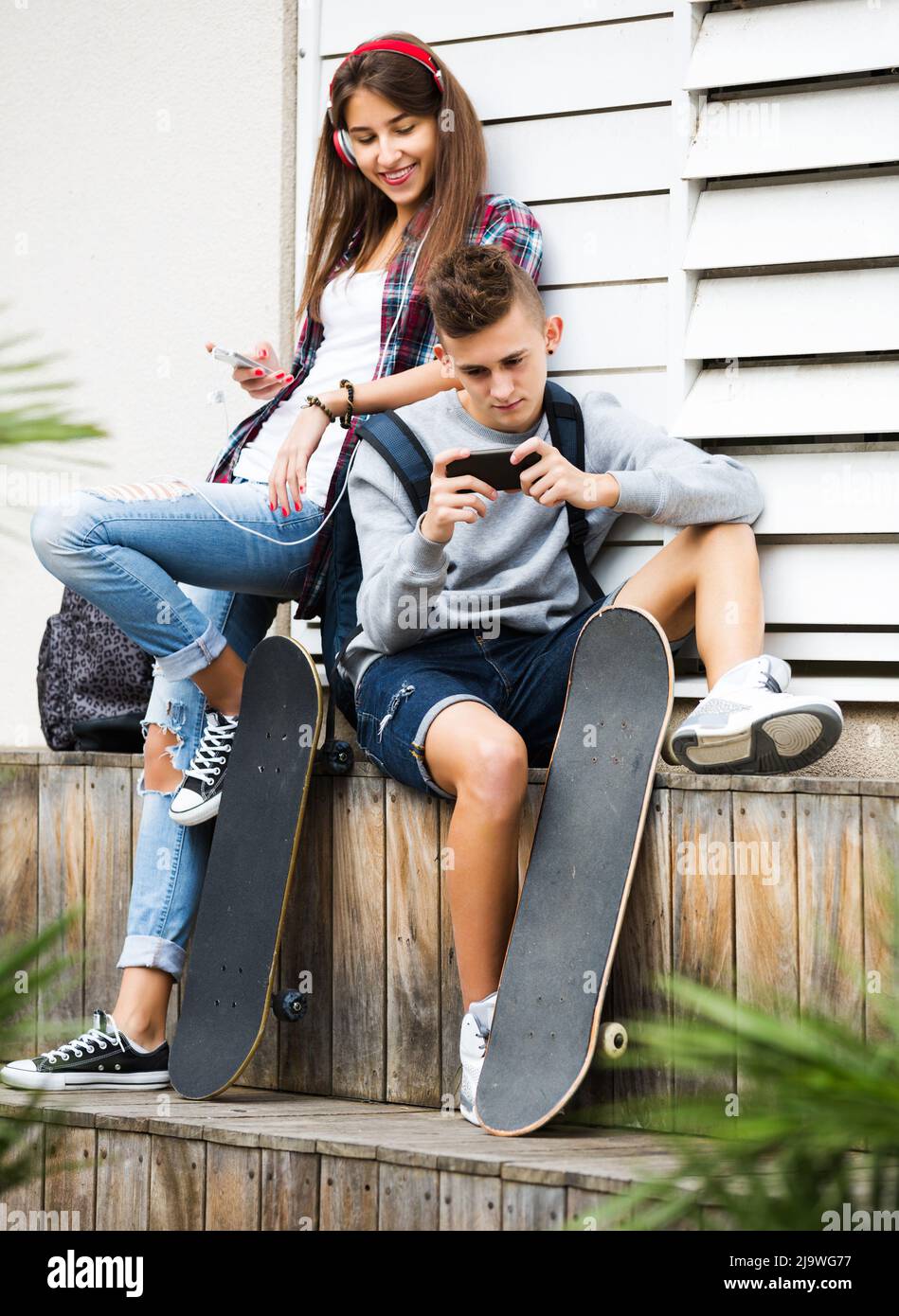 Teenage relaxing with mobile phones Stock Photo - Alamy