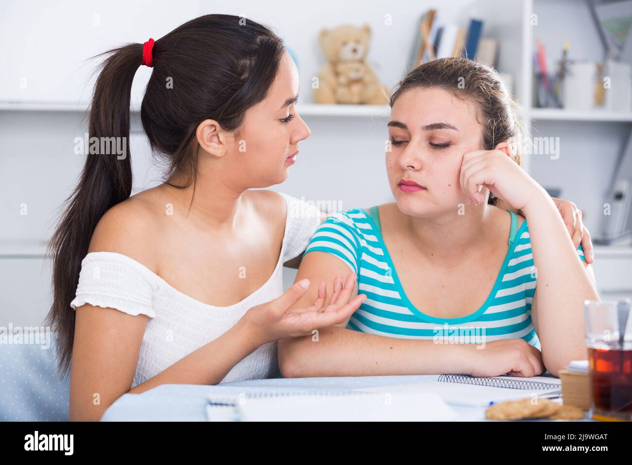Teenage girl calming her friend Stock Photo - Alamy