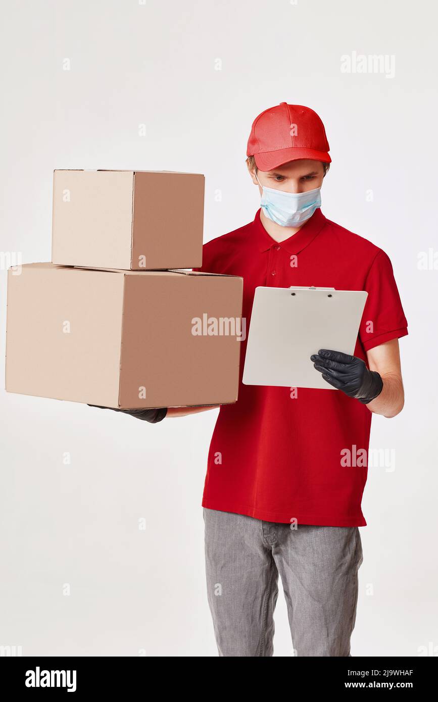 Delivery man employee in red cap face mask, empty cardboard box Stock ...