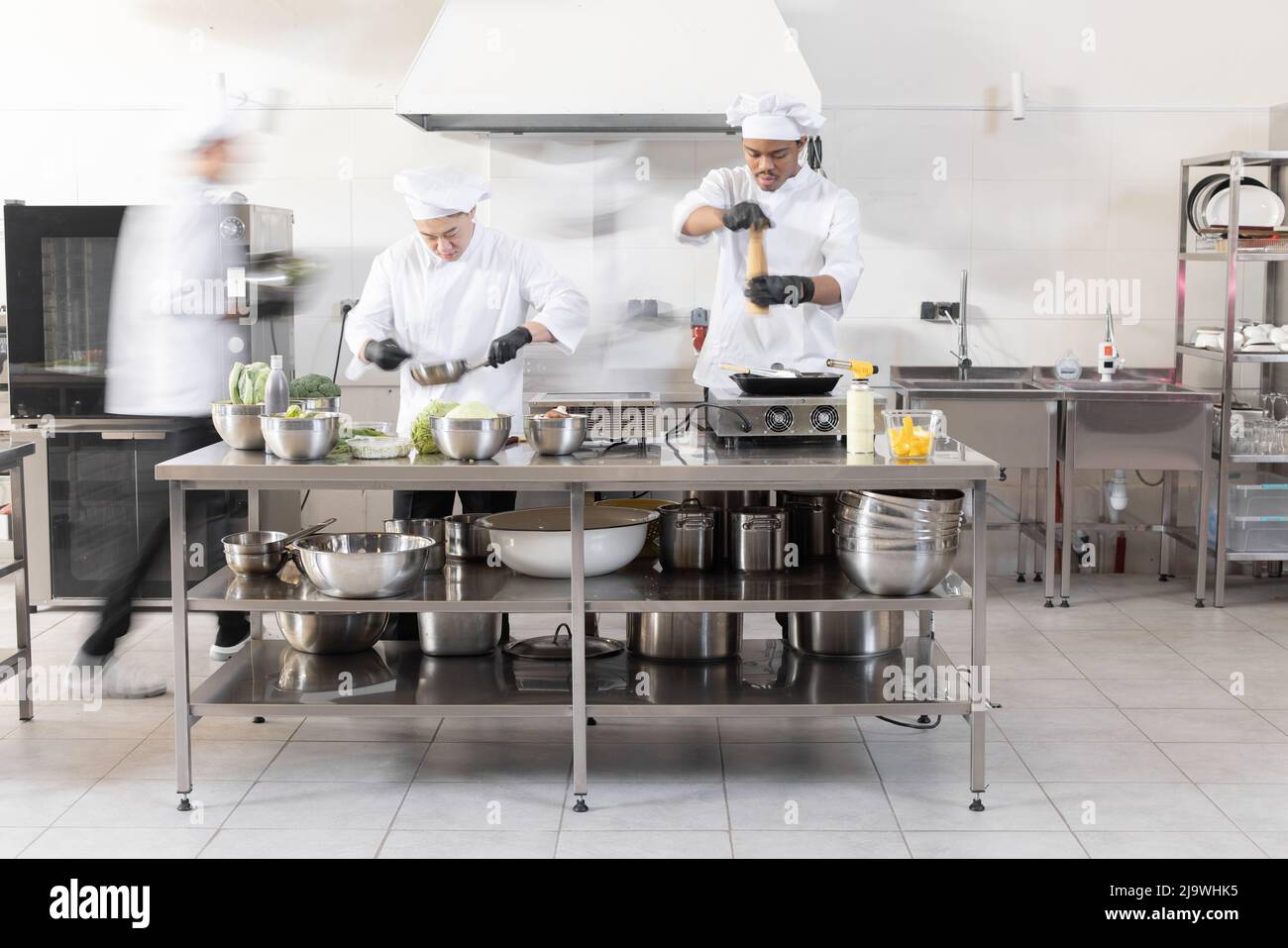 Chef cooks working in professional kitchen. Chefs hurry up, actively ...