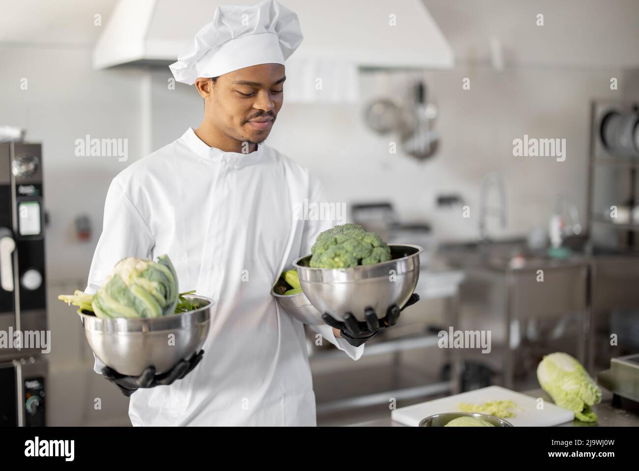Portrait of young chef standing with healthy food ingredients, ready ...