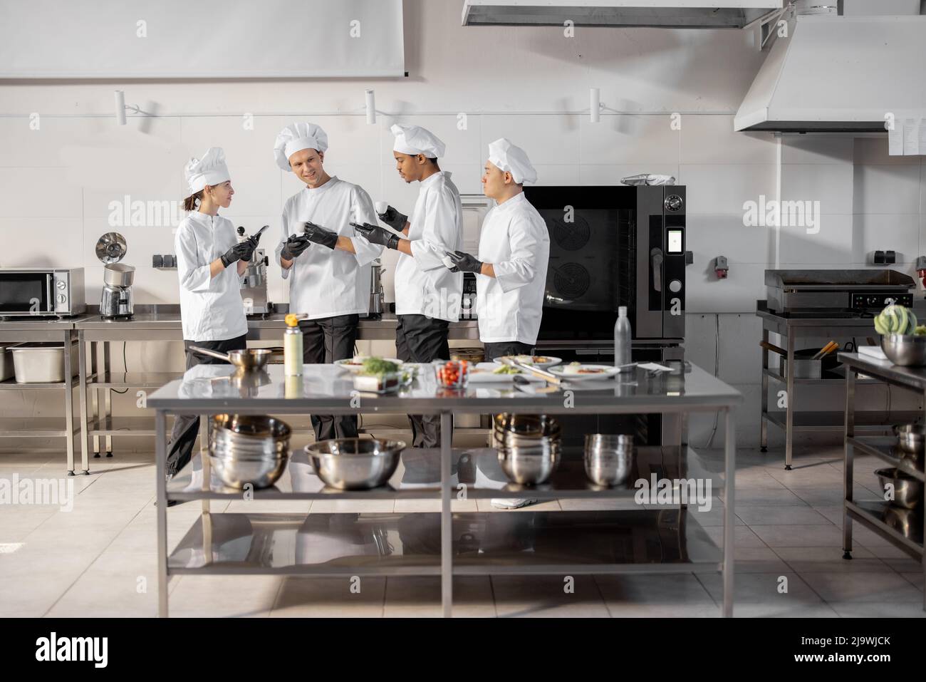 Team of multiracial cooks having conversation during a coffee break in ...