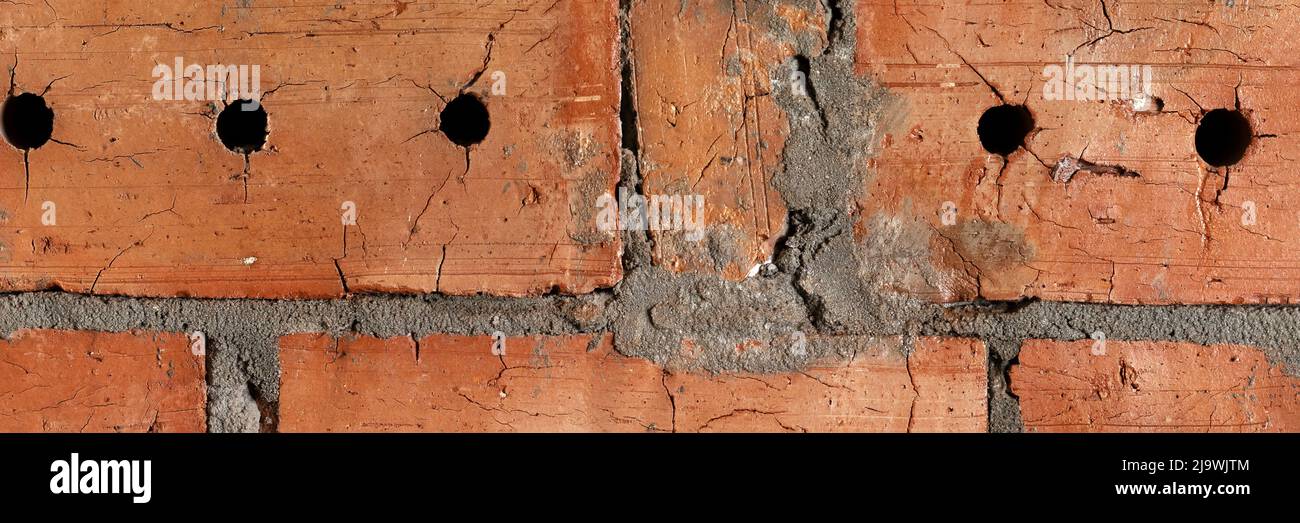 Red cracked brick wall with holes background texture banner. Panoramic ...