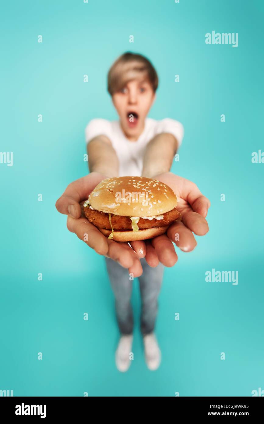 Very hungry young man holding tasty hamburger Stock Photo - Alamy