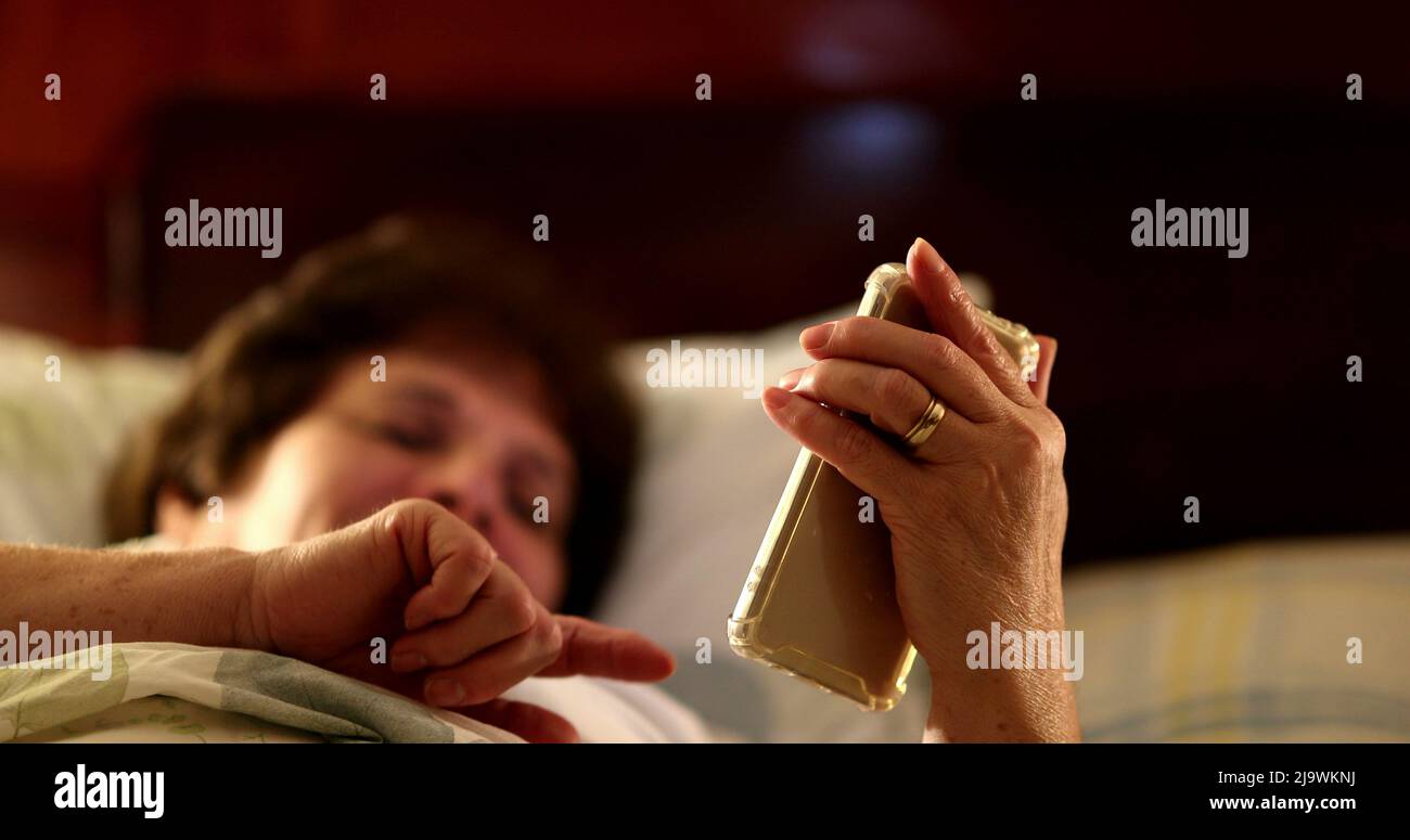 Married couple in bed using smartphone Stock Photo - Alamy