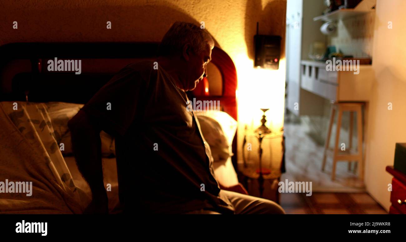 Old man laying down in bed and turning night lamp off Stock Photo - Alamy