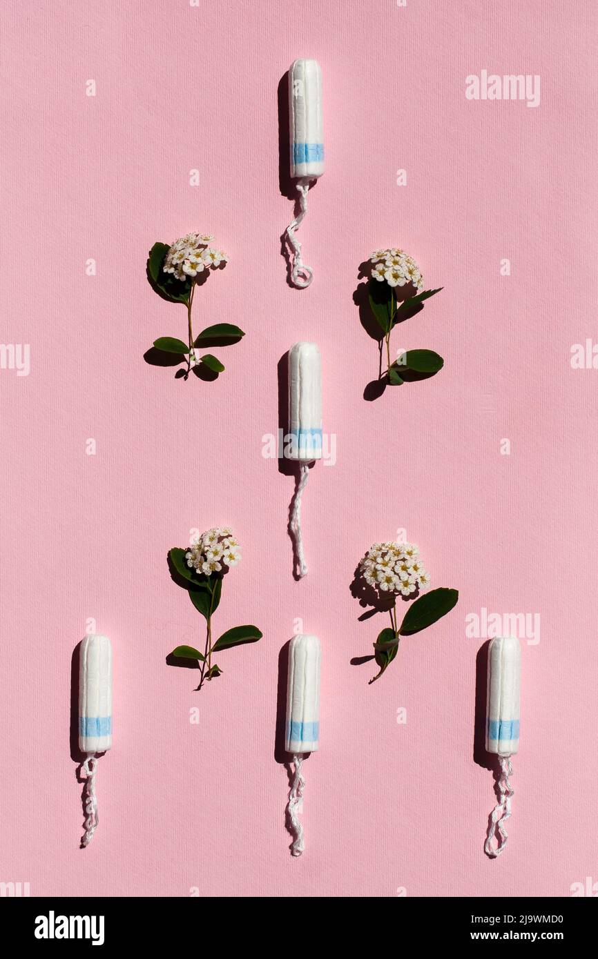 Medical female tampon and white flowers on a pink background. Hygienic ...