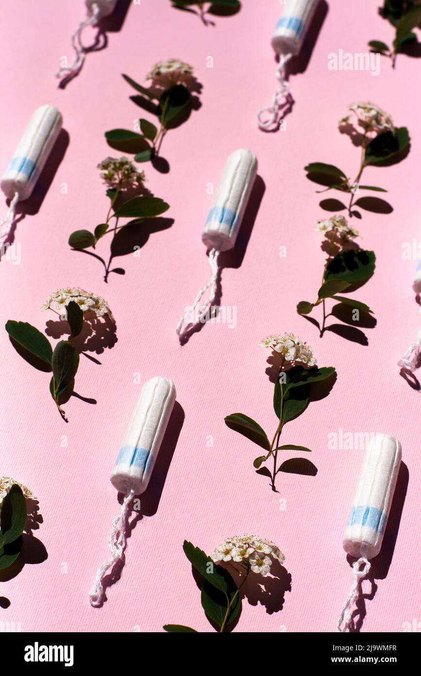Medical female tampon and white flowers on a pink background. Hygienic ...