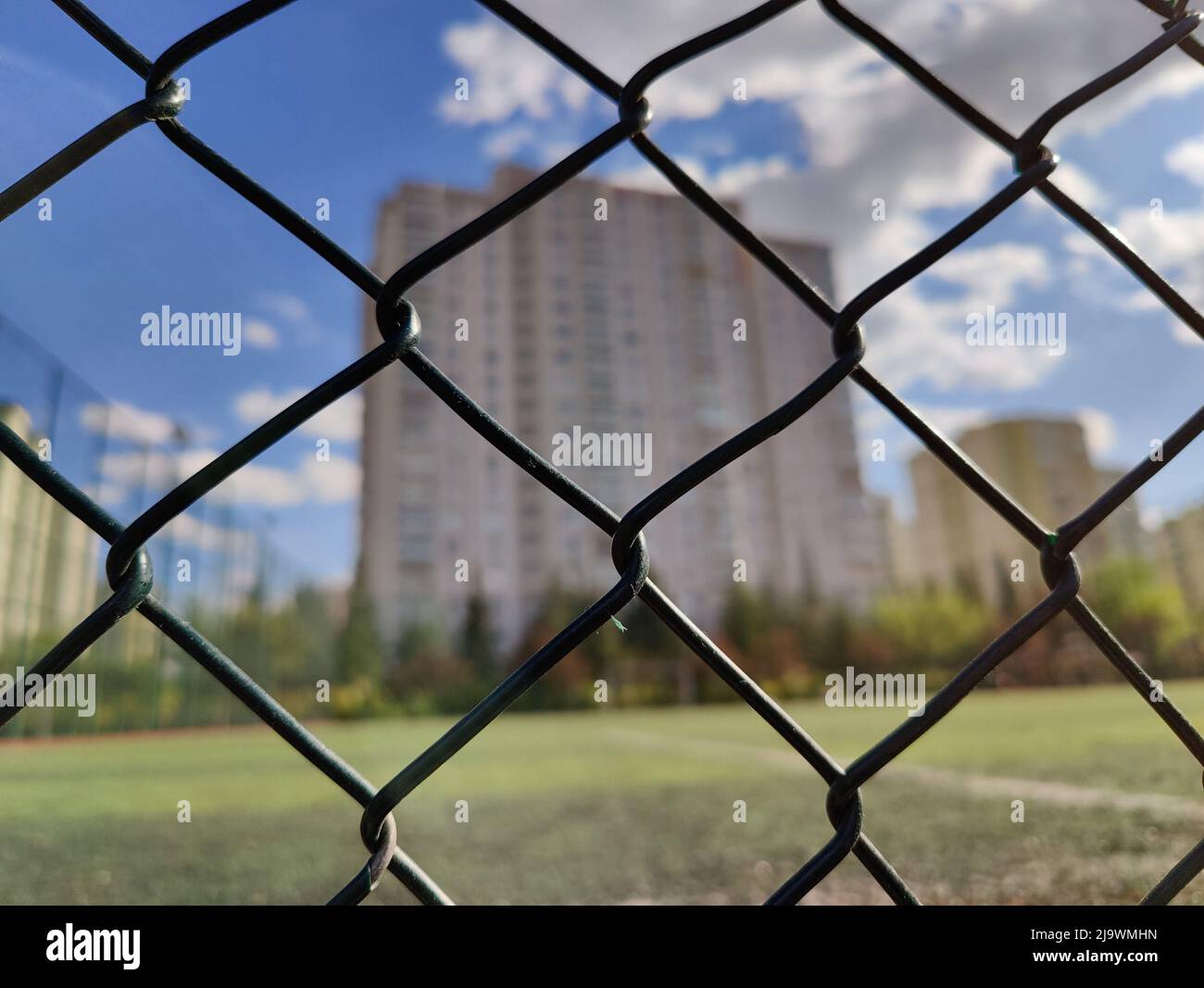 tall building behind football field fence Stock Photo - Alamy