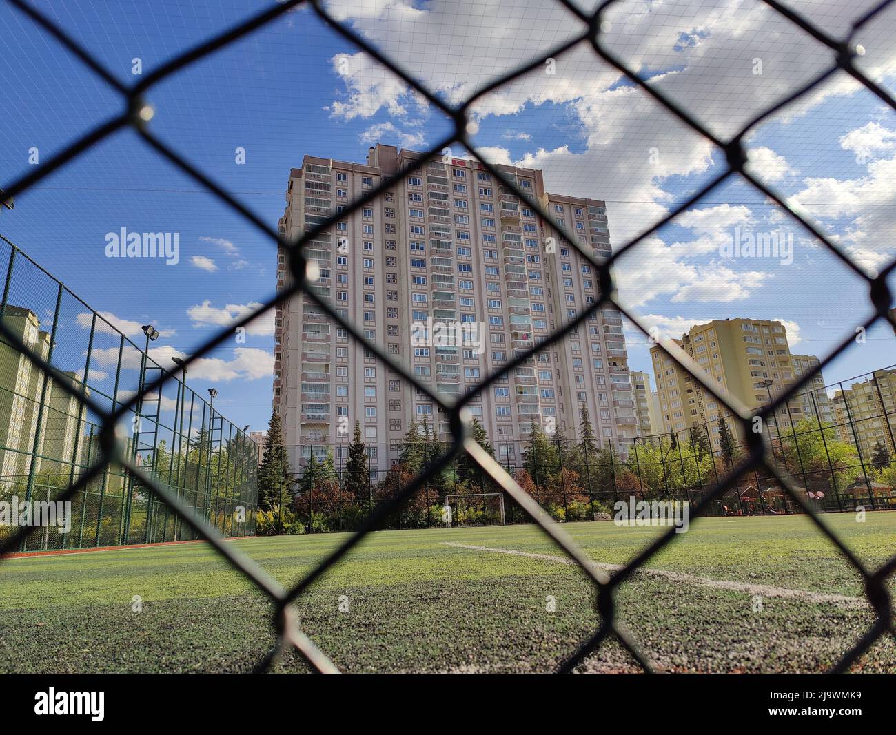 tall building behind football field fence Stock Photo - Alamy