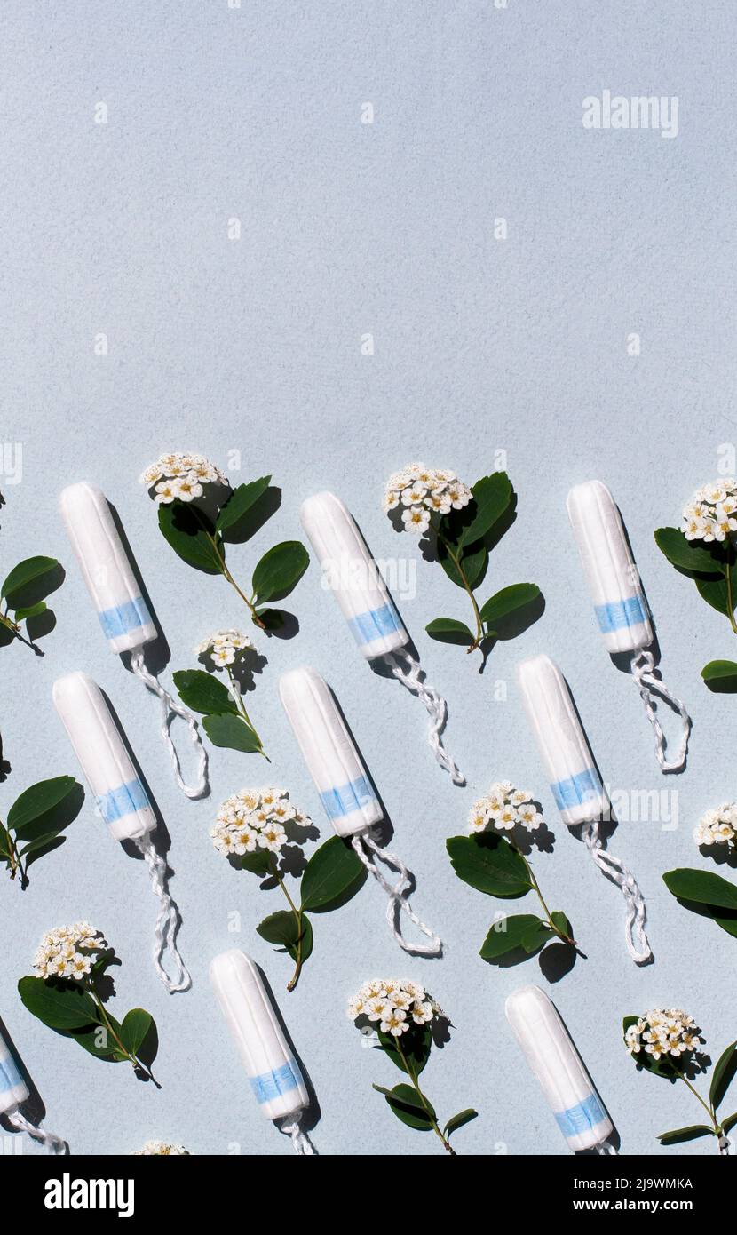 Medical female tampon and white flowers on a blue background. Hygienic ...