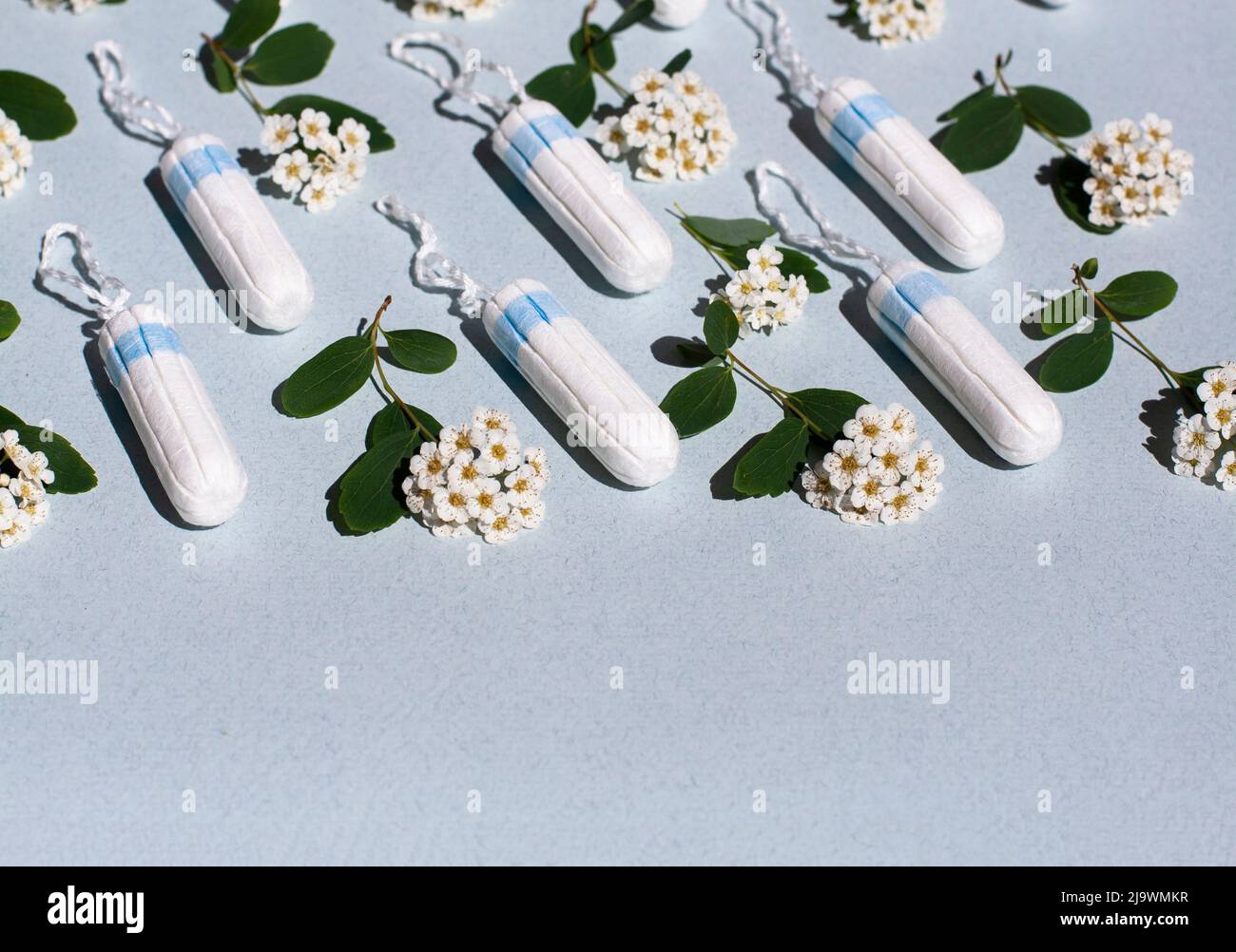 Medical female tampon and white flowers on a blue background. Hygienic ...