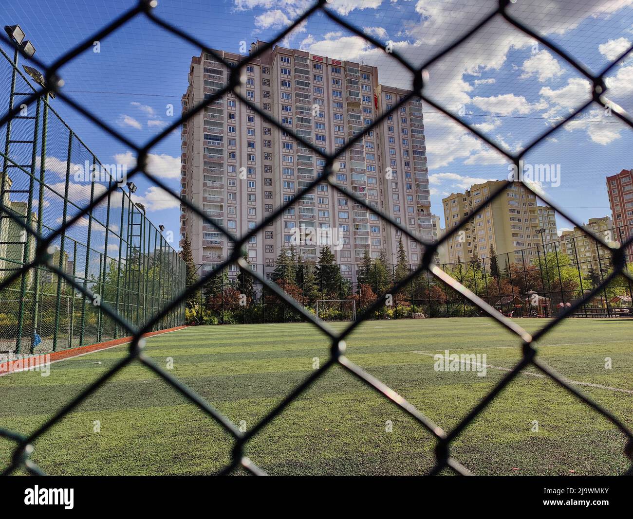 tall building behind football field fence Stock Photo - Alamy
