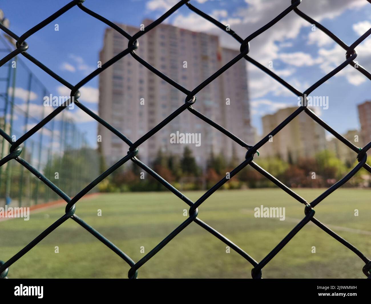 tall building behind football field fence Stock Photo - Alamy