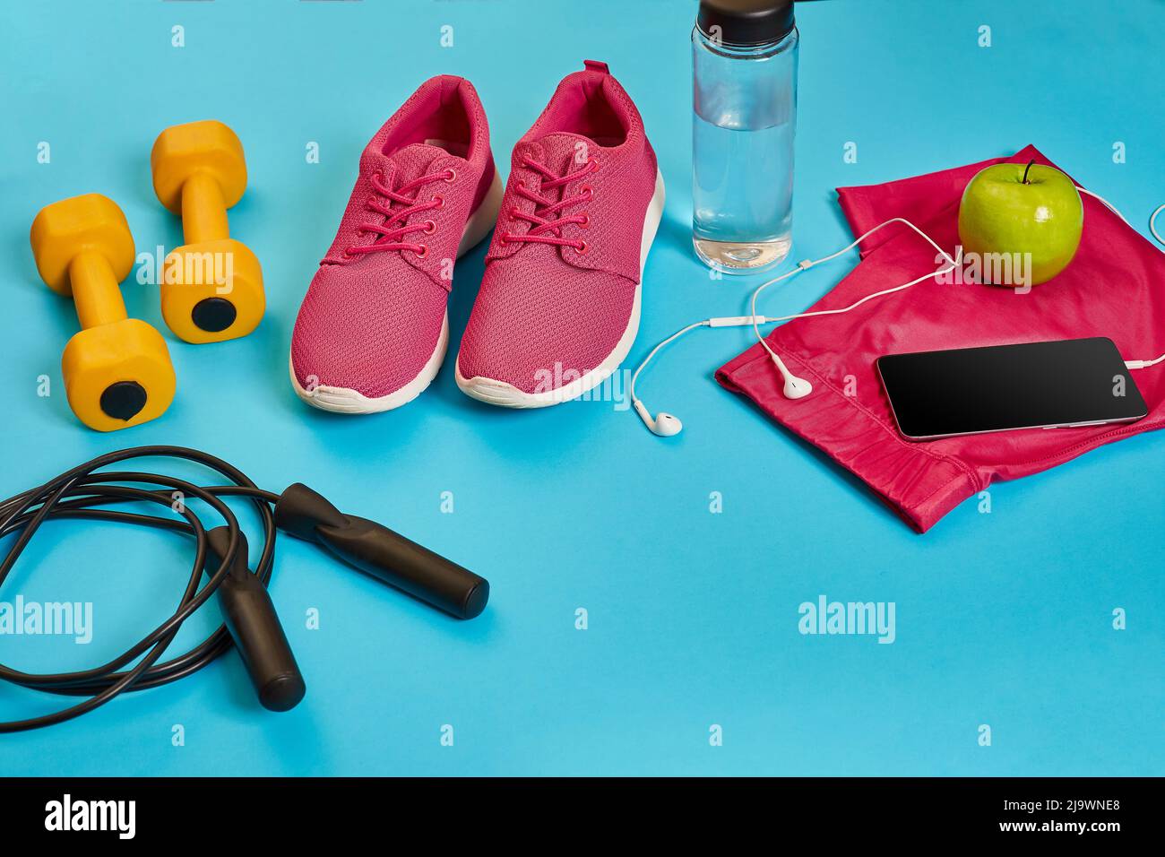 Flat lay of dumbbell, bottle of water, jump rope and sneaker, sport ...