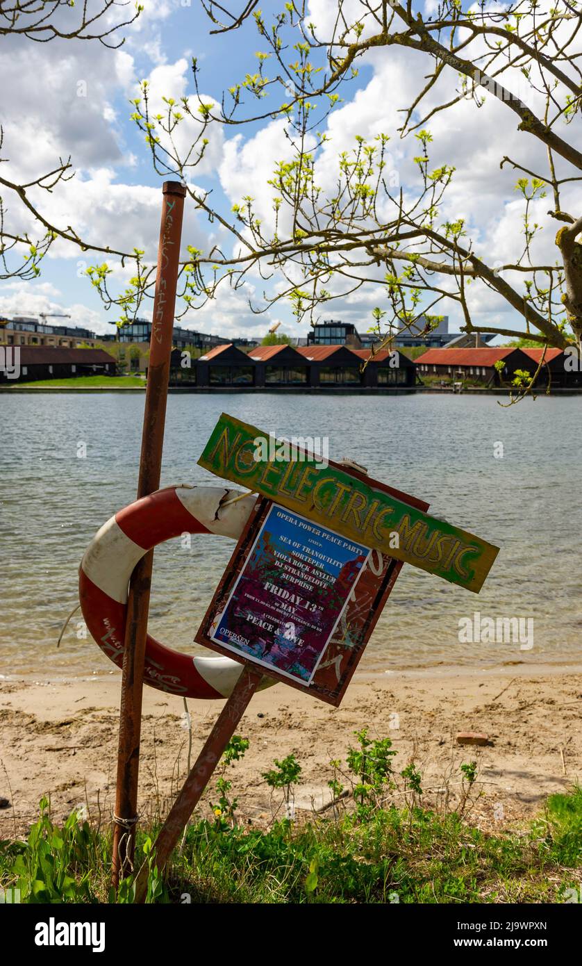 A lifebuoy on the beach alongside a "No Electric Music"sign in ...