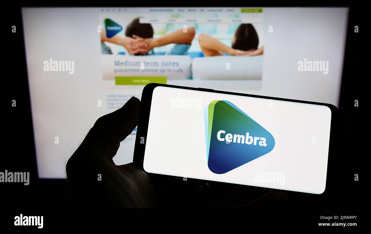 Person holding smartphone with logo of Swiss financial company Cembra ...