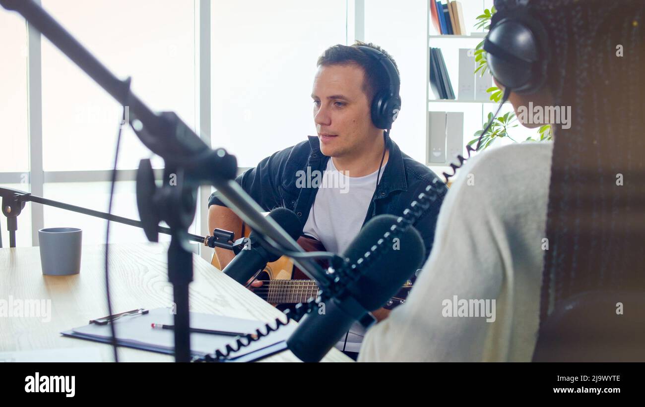 An Influential Musician Sings and Plays the Guitar During a Radio ...