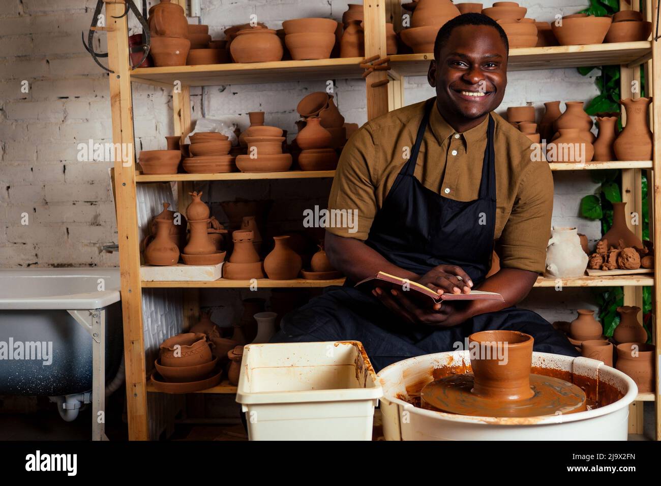 happy African American businessman potter male owner making clay ...