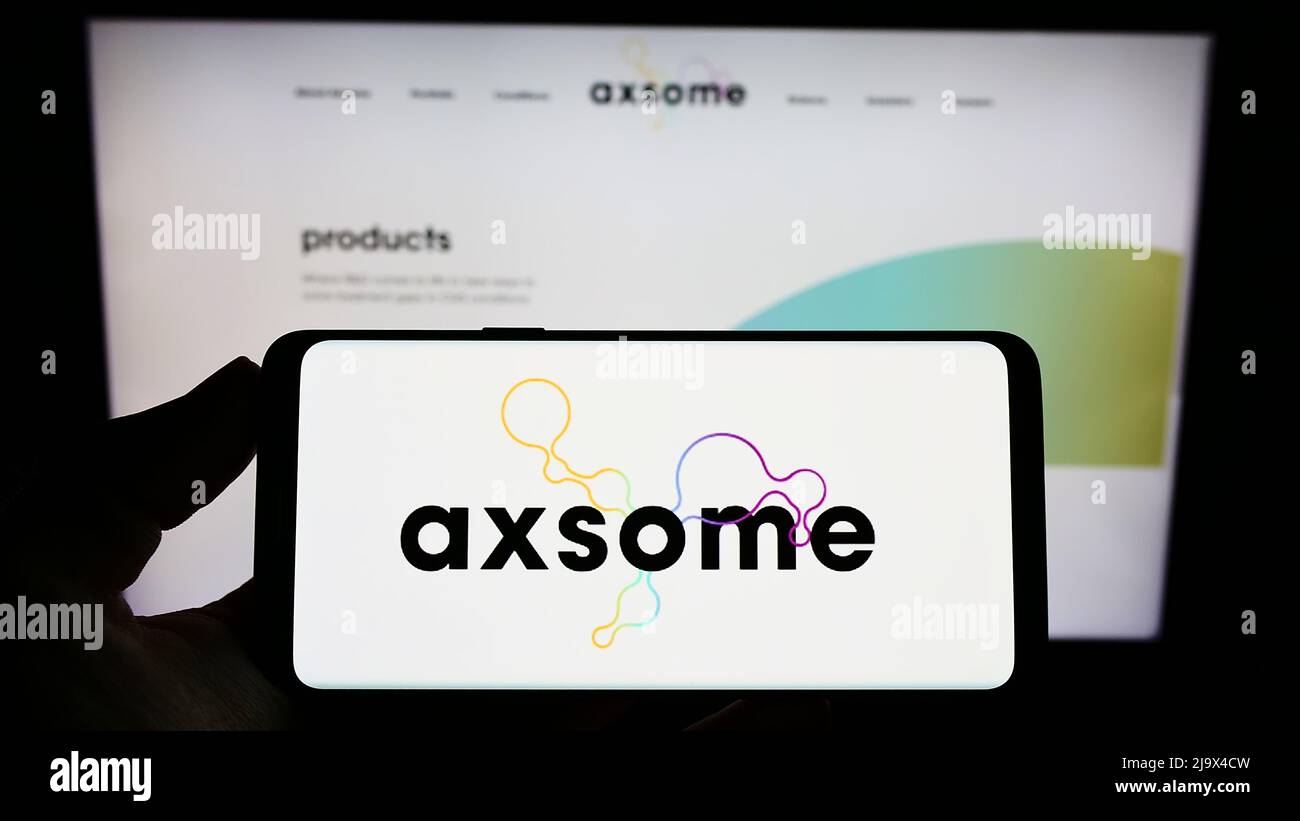 Person holding smartphone with logo of US company Axsome Therapeutics ...