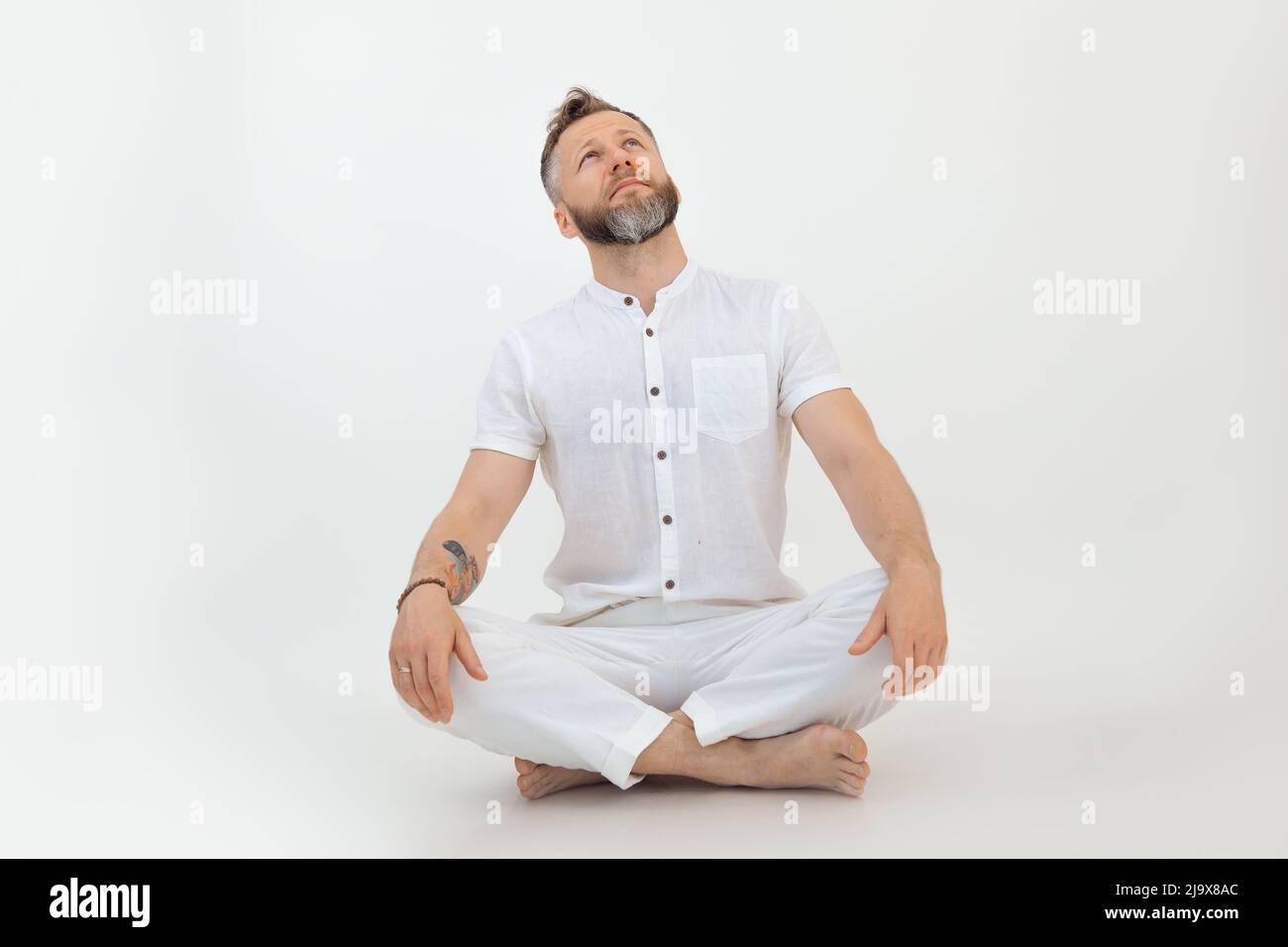 Bearded sporty handsome man tutor sit in lotus posture, on white ...