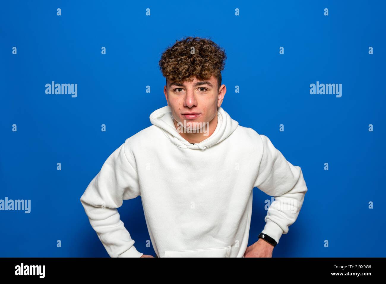 Cheerful young Caucasian man posing isolated on a blue background ...