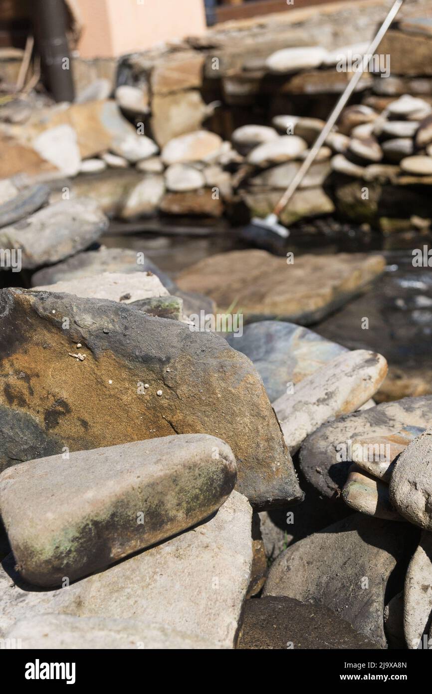 Large dirty stones in the background of the pool. Construction and ...