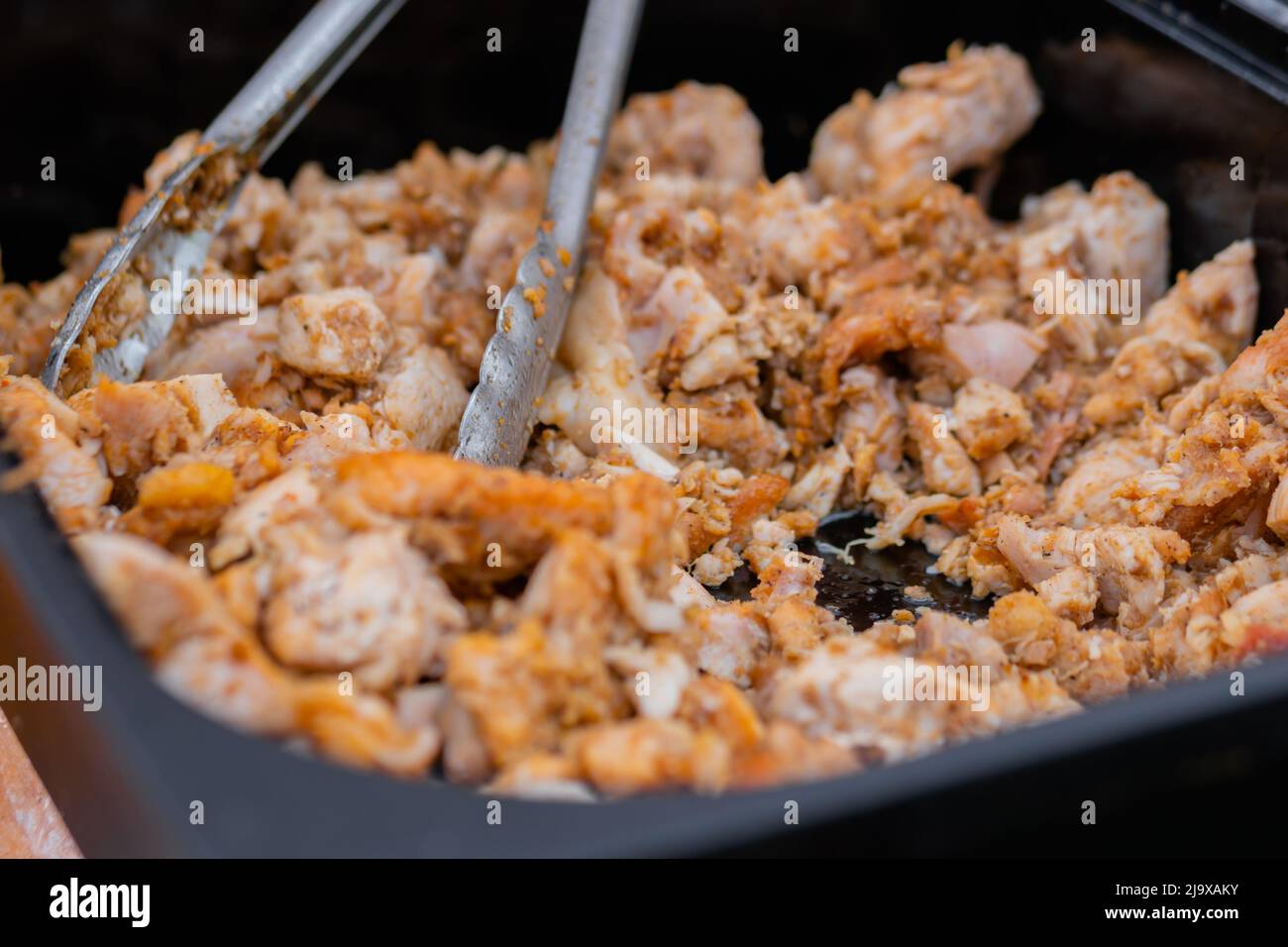 Cooked roasted chicken meat pieces in food container at local food ...