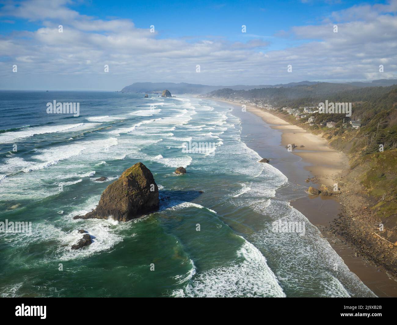 Emerald ocean water, white light waves, a large stone near the shore ...