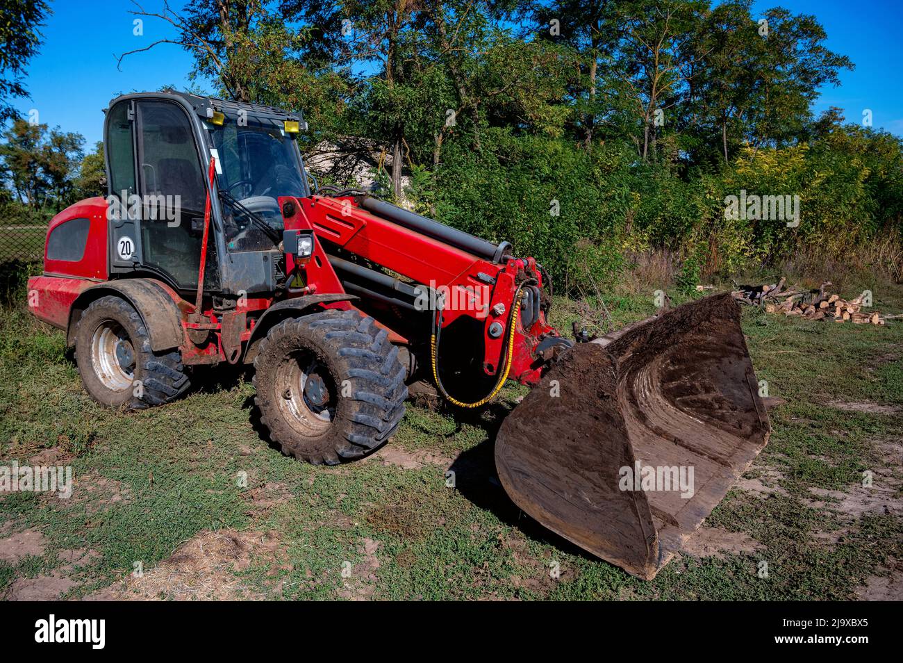 Modern red front wheel loader on a farm Stock Photo - Alamy