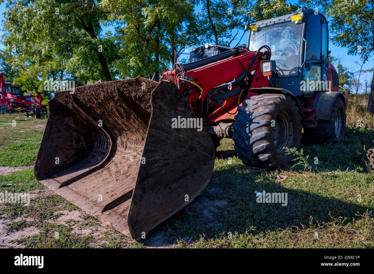 Modern red front wheel loader on a farm Stock Photo - Alamy