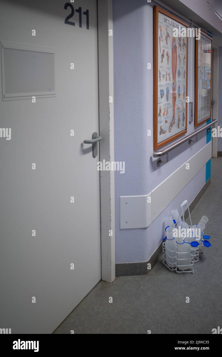 in the corridor of a hospital ward there are empty urine bottles in ...