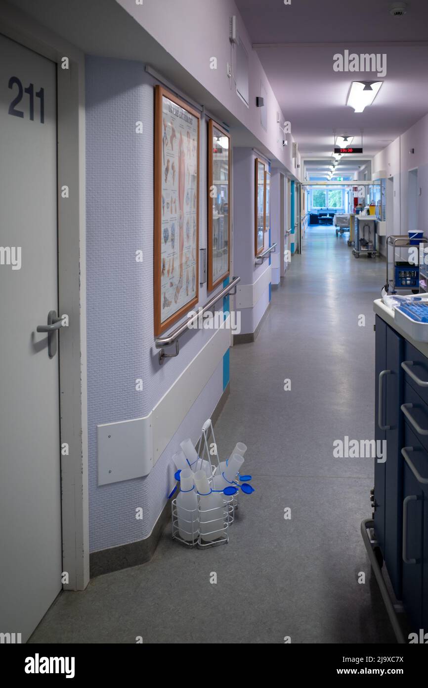 in the corridor of a hospital ward there are empty urine bottles in ...