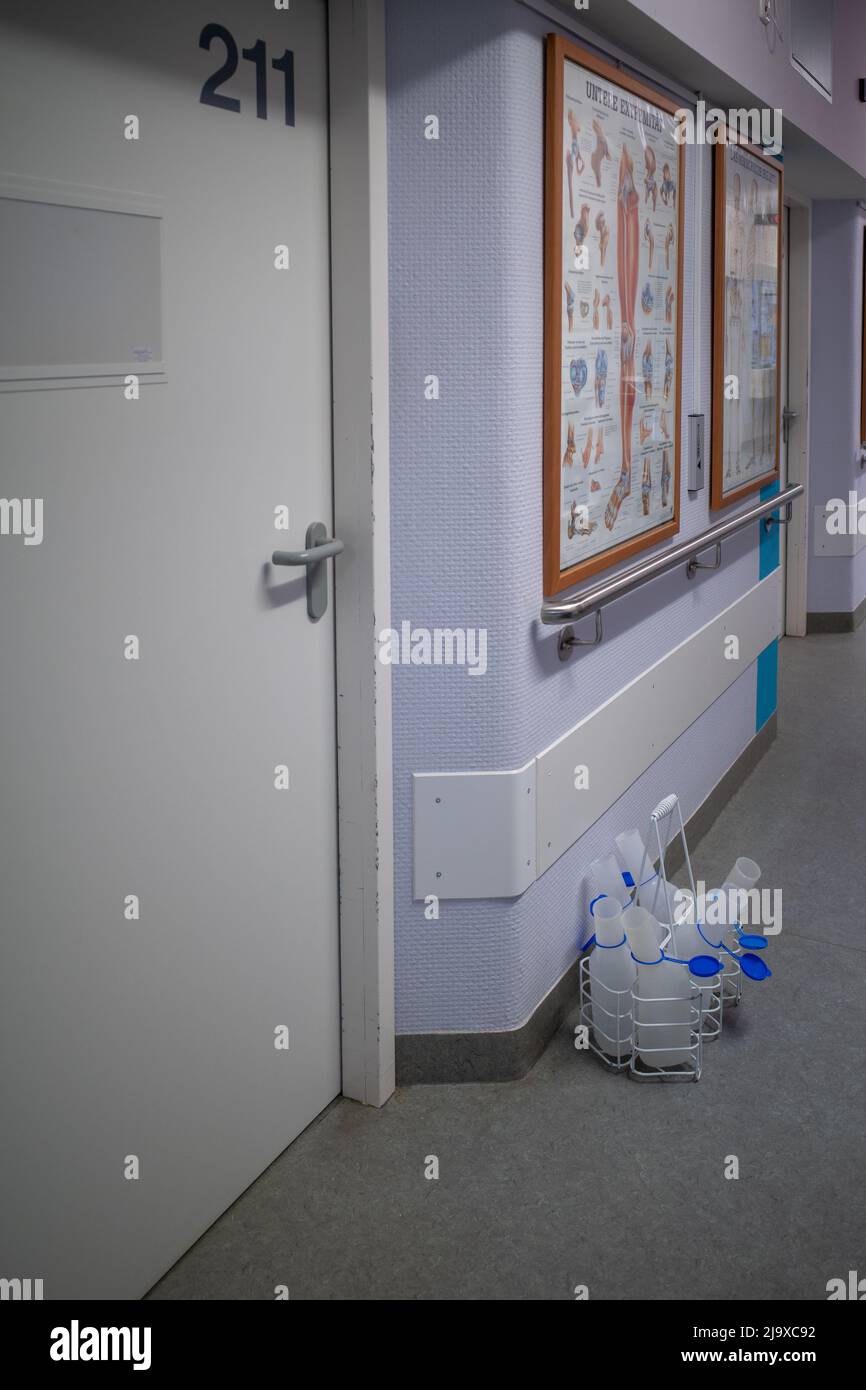 in the corridor of a hospital ward there are empty urine bottles in ...