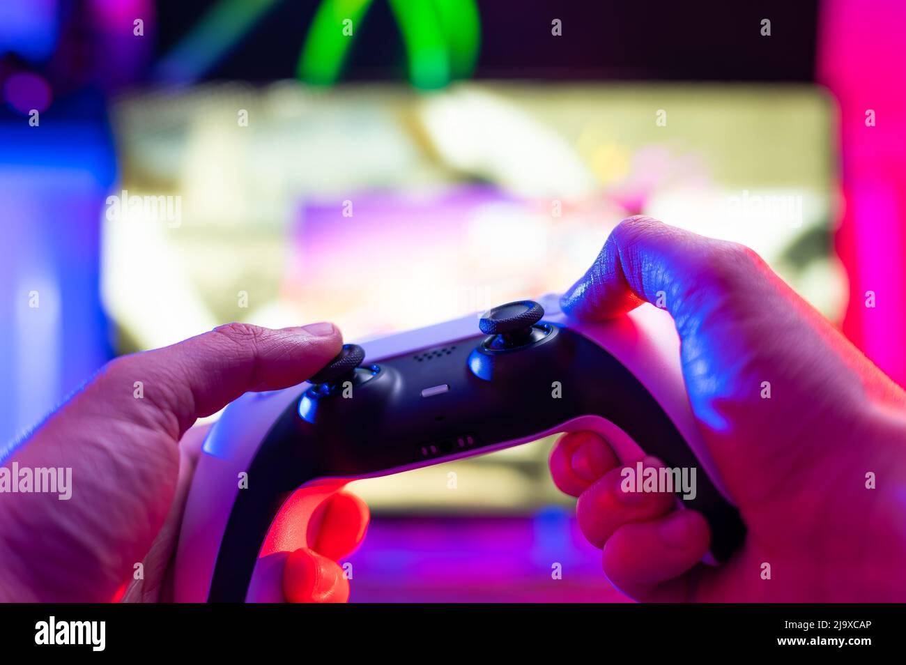 A gamer plays a video game with a joystick in his hands. Close-up ...