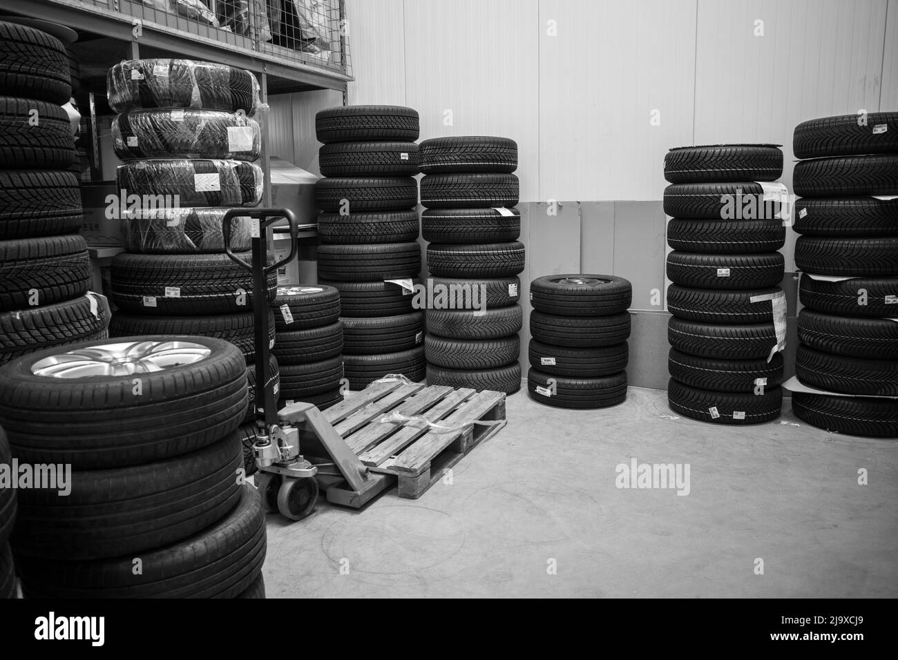 in the depot of a car repair shop there are many summer tires ready for ...