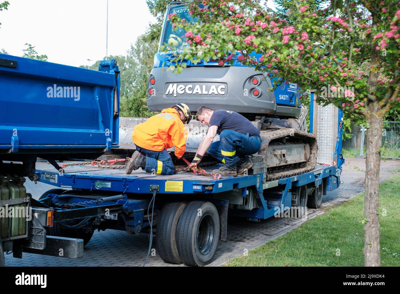 Employees of the THW technical relief organization attach an excavator ...