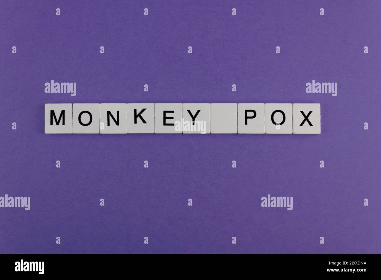 MONKEY POX. Word written on square wooden tiles on purple background ...