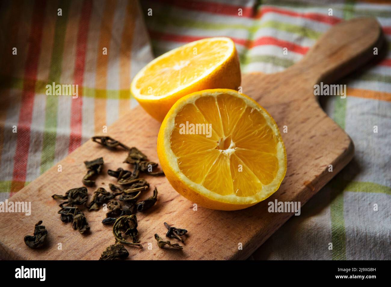 Still life with spill split in half lemon green tea on a wooden board ...