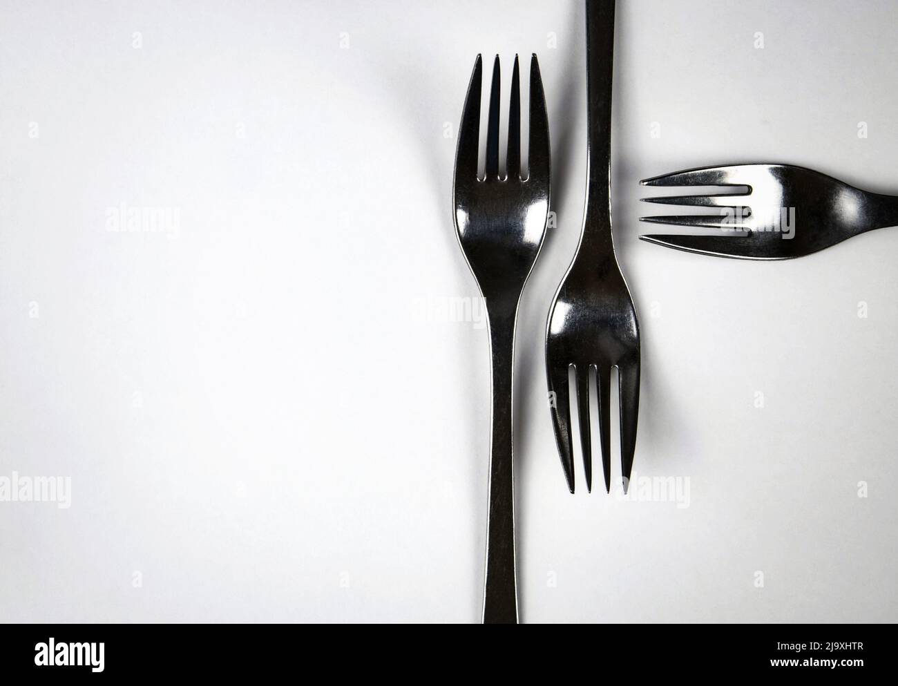 background abstract composition of three forks Stock Photo - Alamy