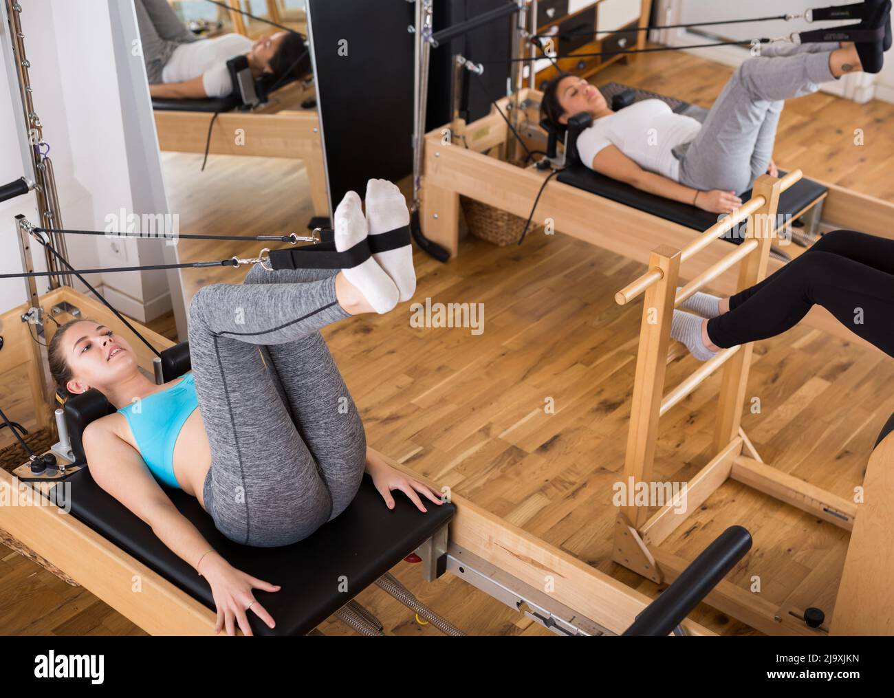 Group of women doing exercises during pilates reformer class Stock ...