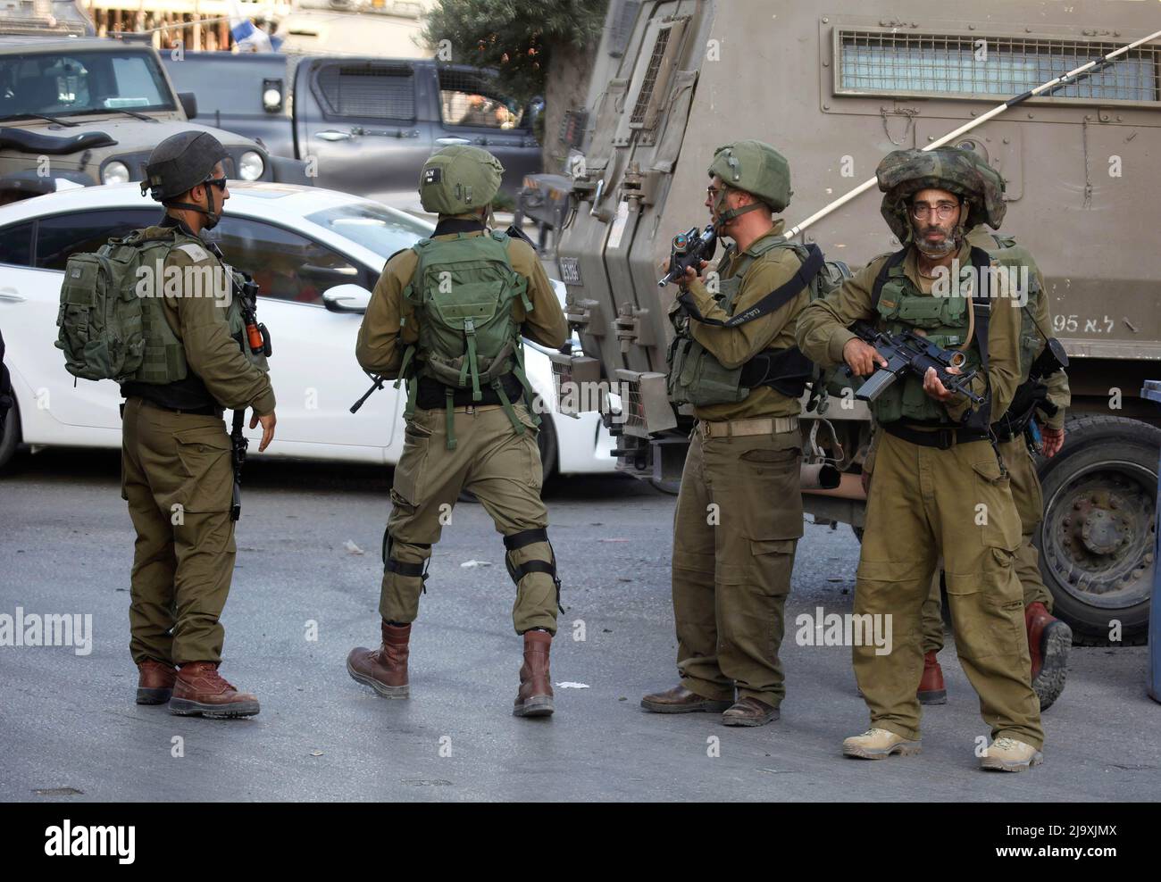 Israeli soldiers stand by while protecting Jewish settlers during a "March For Flags" in the ...