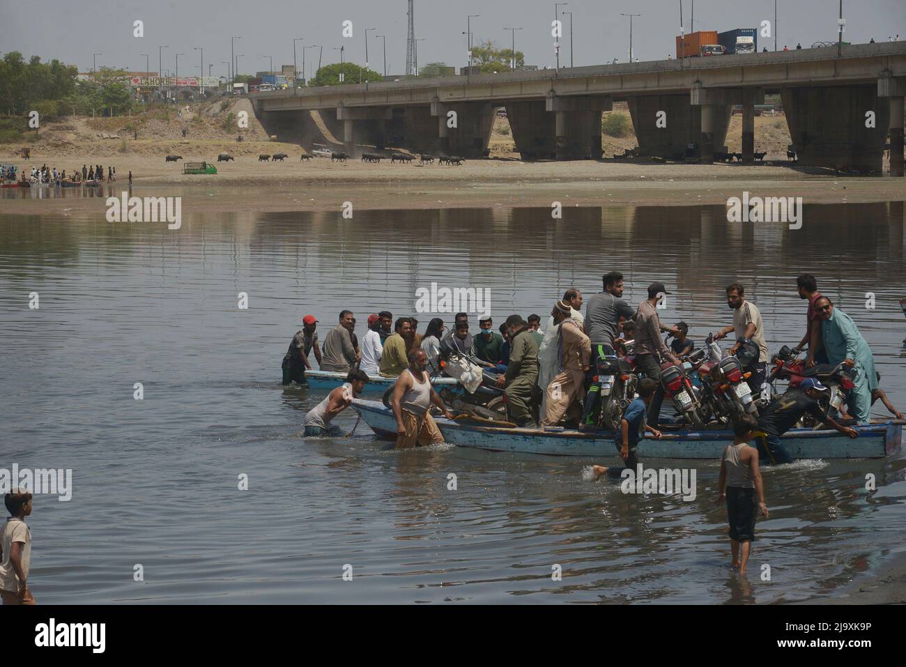 Pakistani people carrying their goods in boats to cross Ravi River ...
