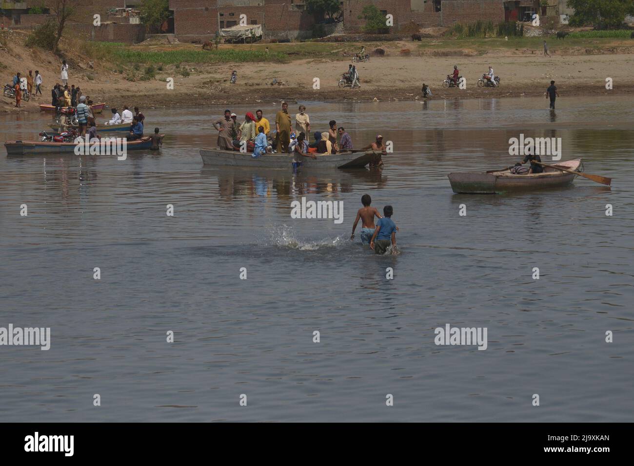 Pakistani people carrying their goods in boats to cross Ravi River ...