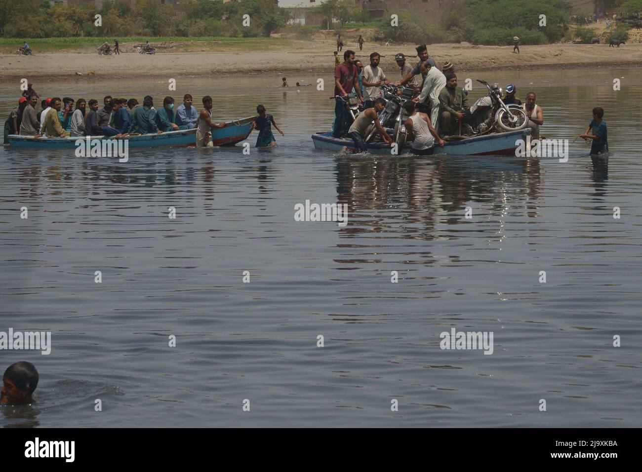 Pakistani people carrying their goods in boats to cross Ravi River ...