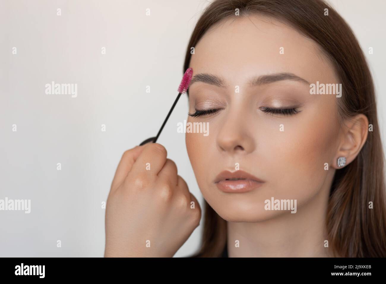 Woman face in spa salon correcting and brushing eyebrows by brush ...