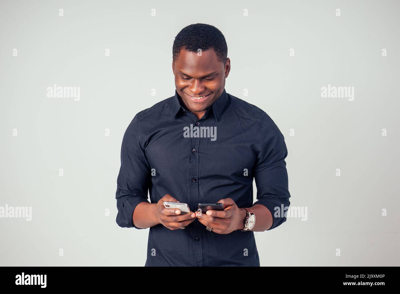 Afro american young holding phone in studio on white background Stock ...