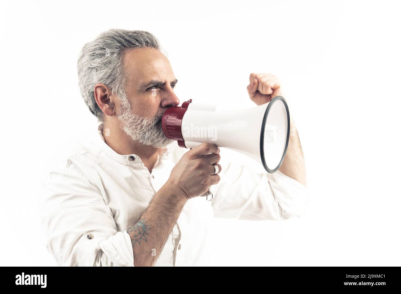 European middle-aged man shouting via loudspeaker over white background ...