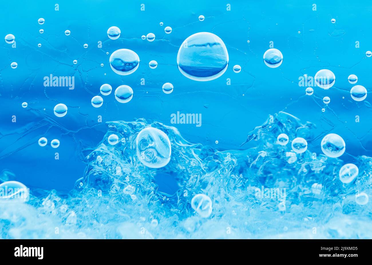 Small bubbles trapped under the ice in the brilliant blue water Stock ...