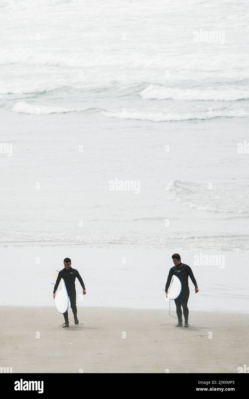 Straight on view of two surfers walking across the beach Stock Photo ...
